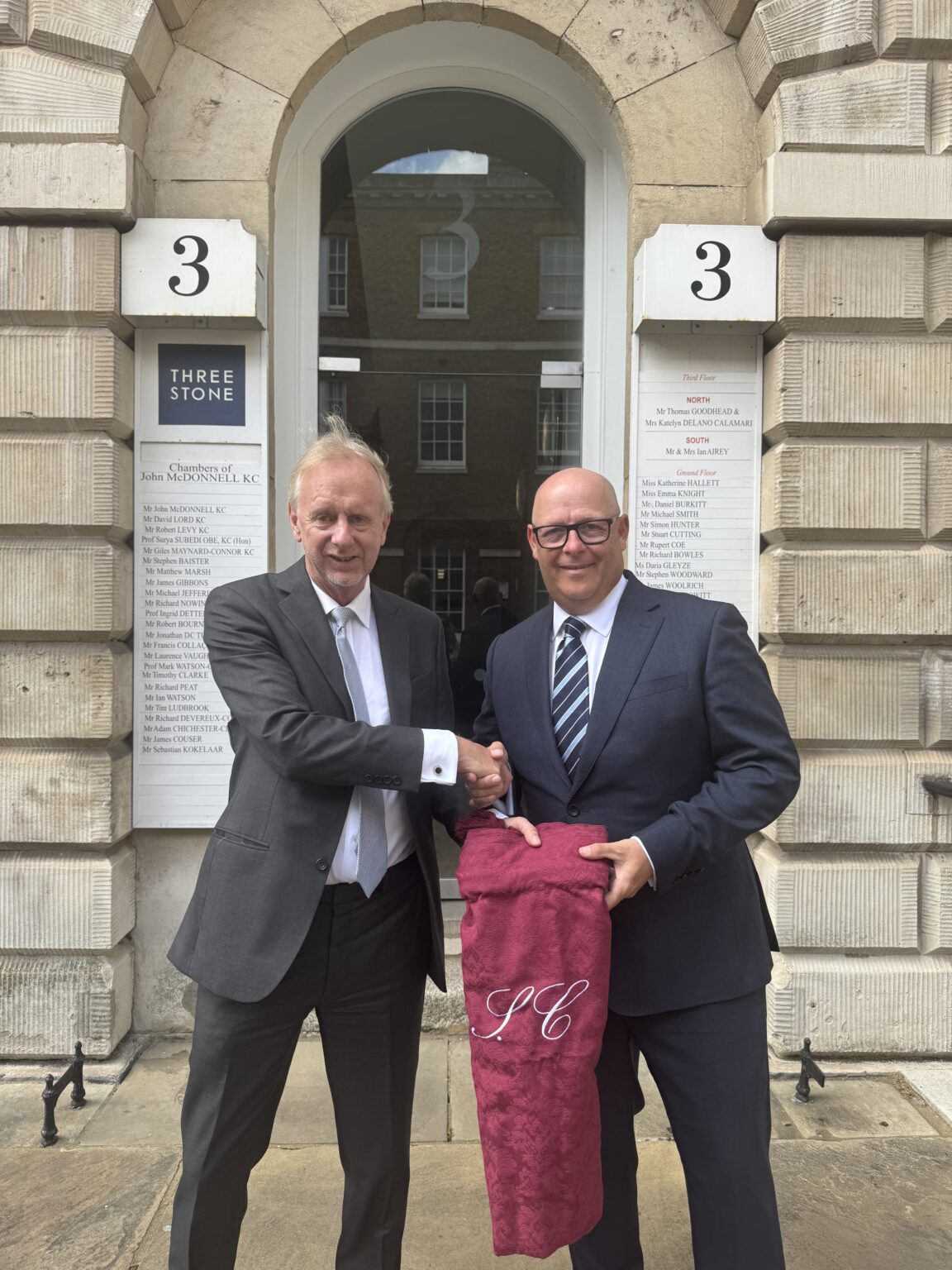 Stuart Cutting presented with a red bag by David Lord KC | Three Stone